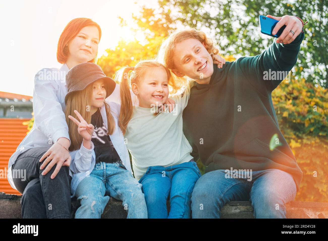 Portraits of three smiling sisters and brother teen taking selfie ...