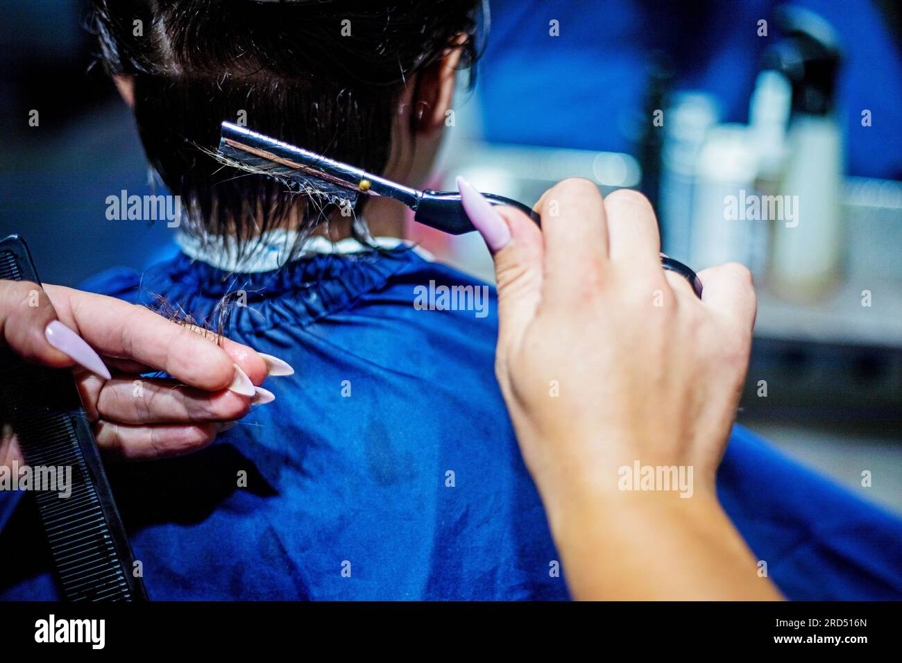 hairdresser cuts the back of the head with scissors under the comb ...