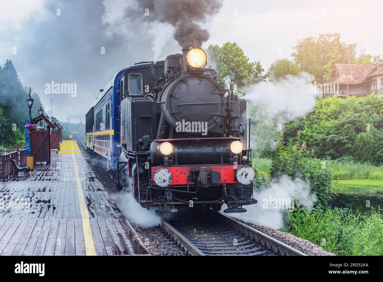 Retro steam train approaches to the platform Stock Photo - Alamy