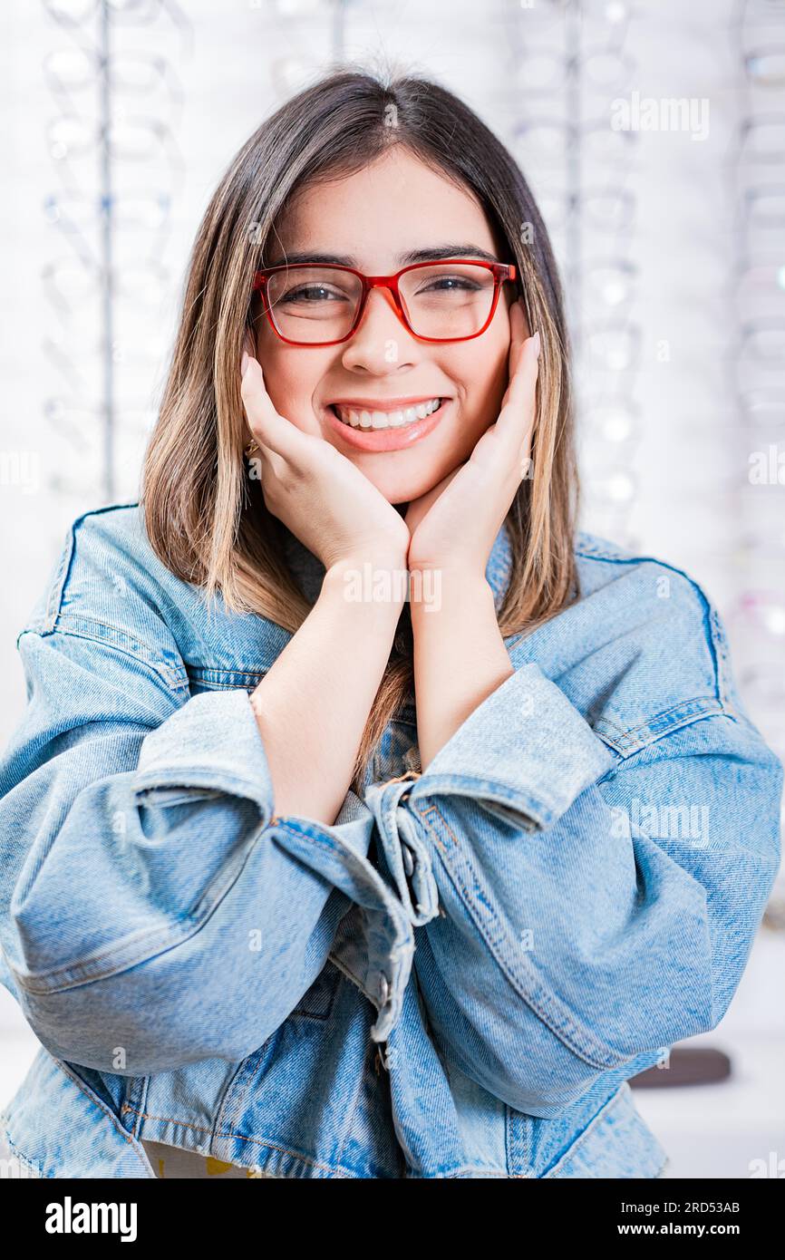 Happy female customer modeling glasses in an optical store. Happy teen ...