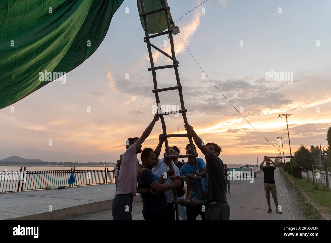 Srinagar, India. 18th July, 2023. Shia Muslims erect an Alam (religious ...