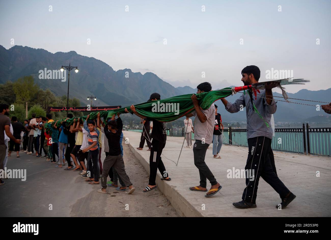 Srinagar, India. 18th July, 2023. Shia Muslims hold an Alam (religious ...
