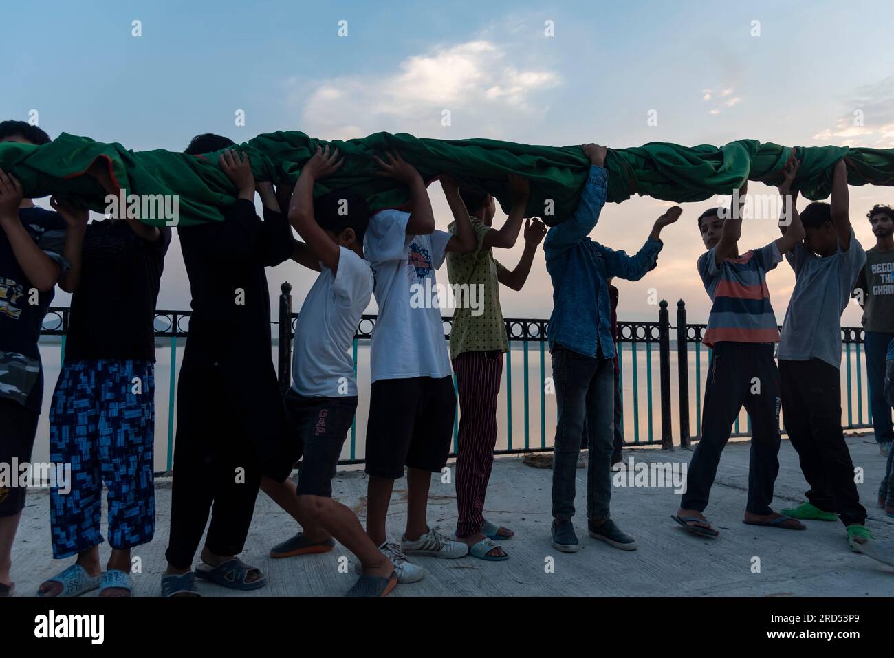 Srinagar, India. 18th July, 2023. Shia Muslims hold an Alam (religious ...