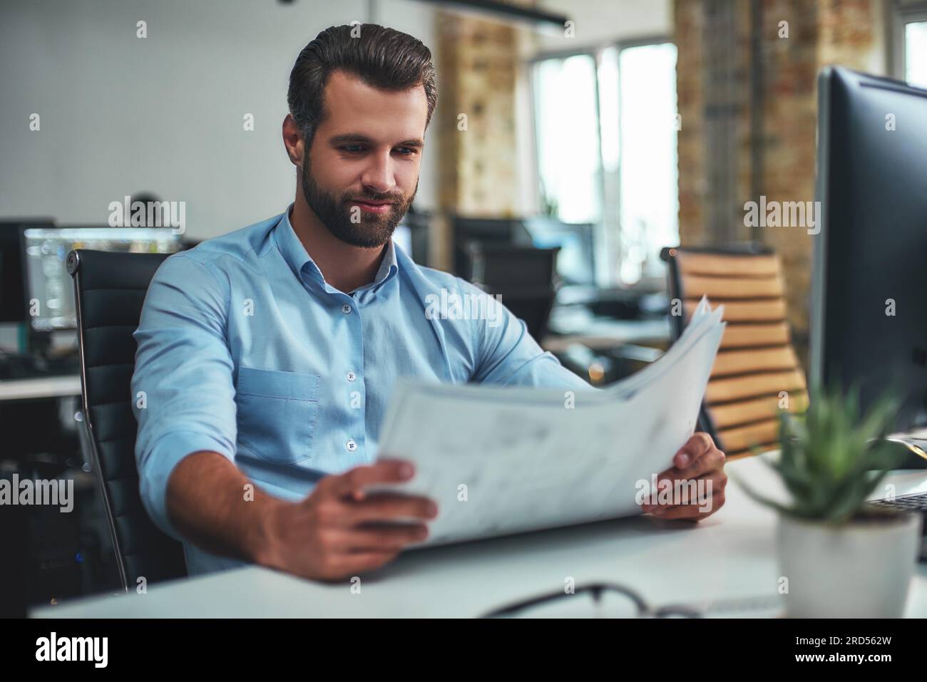 Great work Concentrated bearded engineer in formal wear looking at ...
