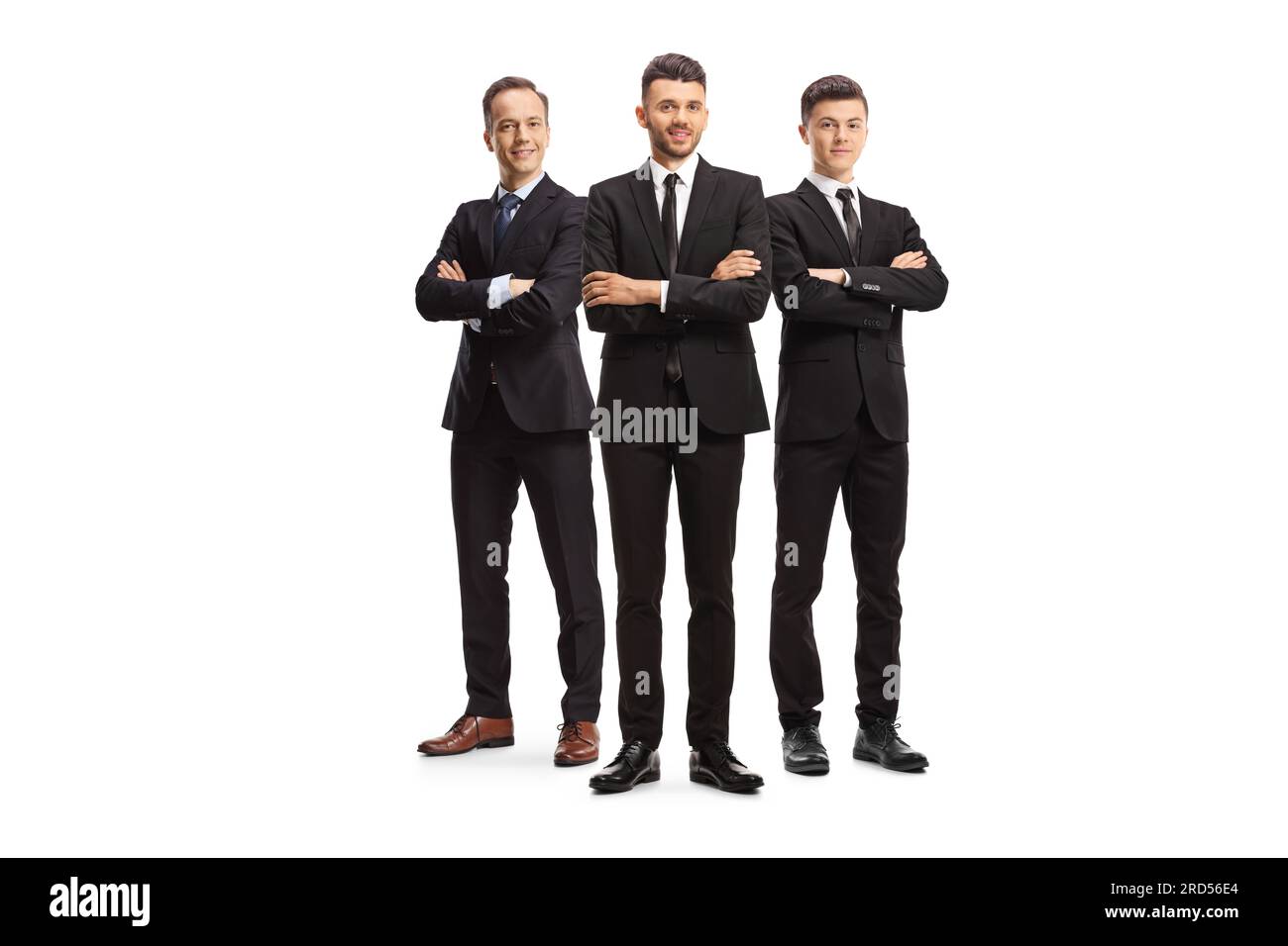 Three young businessmen in black suits posing isolated on white ...