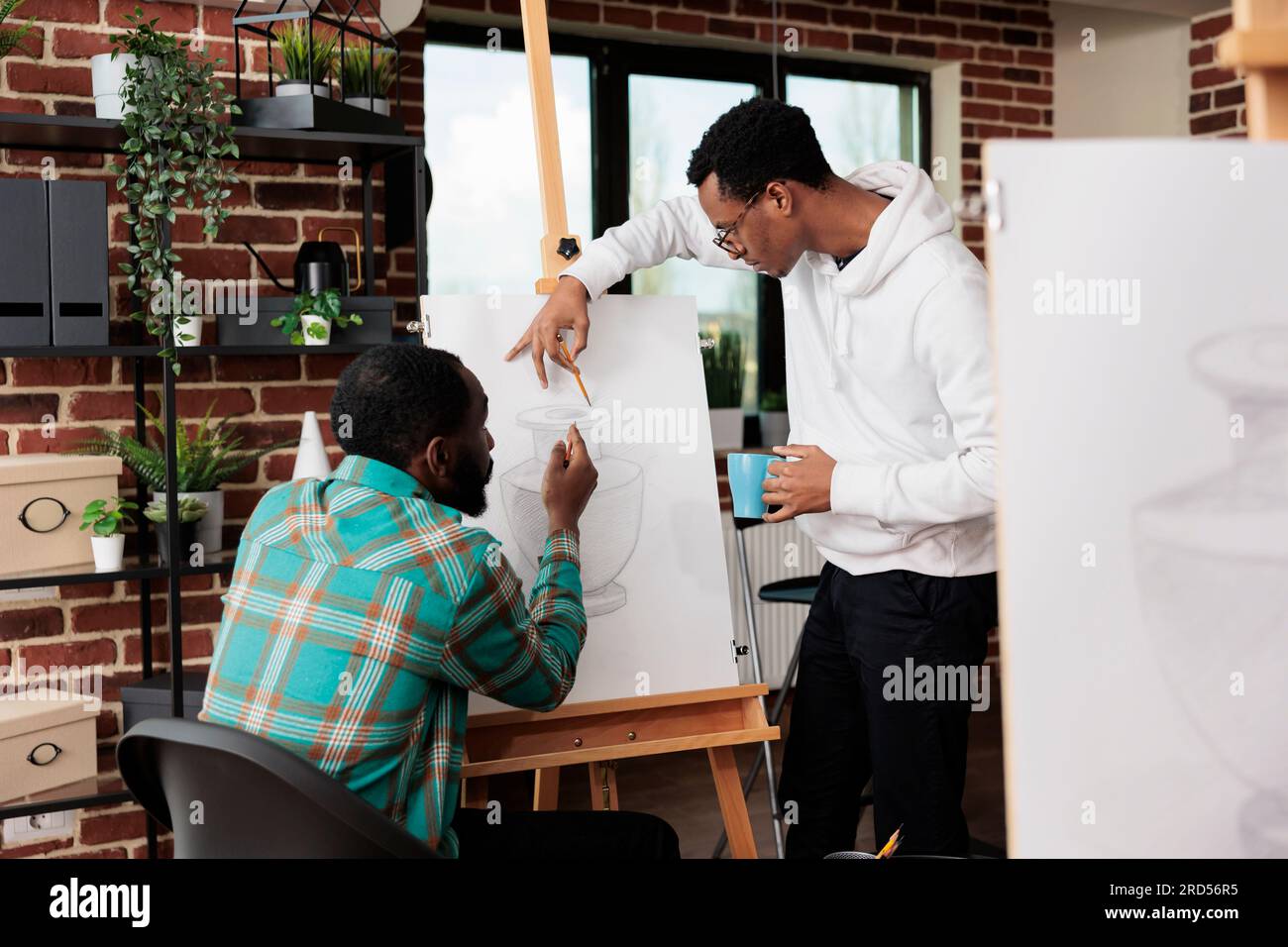 Two African American men friends drawing on canvas during art class ...