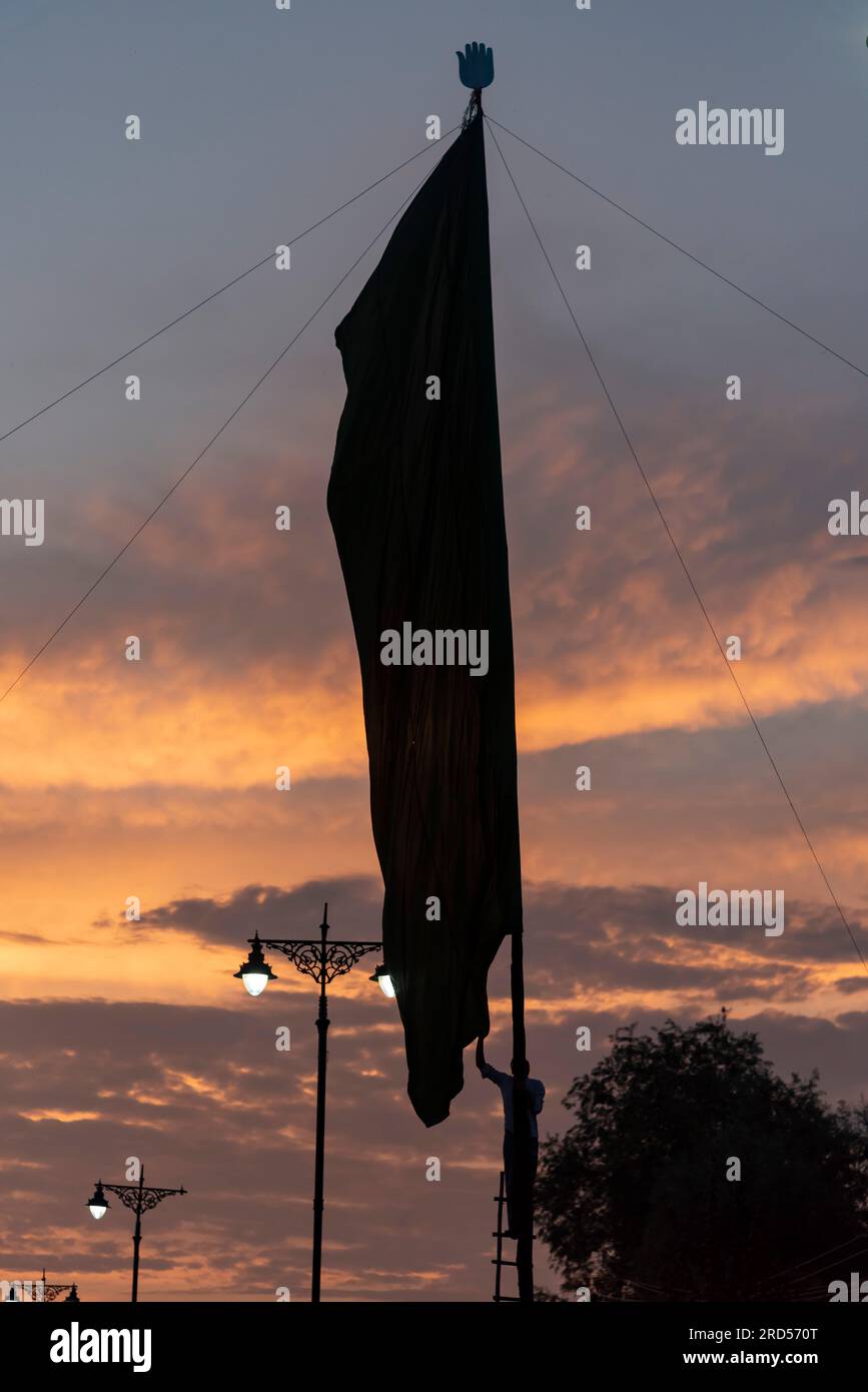 Srinagar, India. 18th July, 2023. A Shia Muslim man corrects an Alam ...