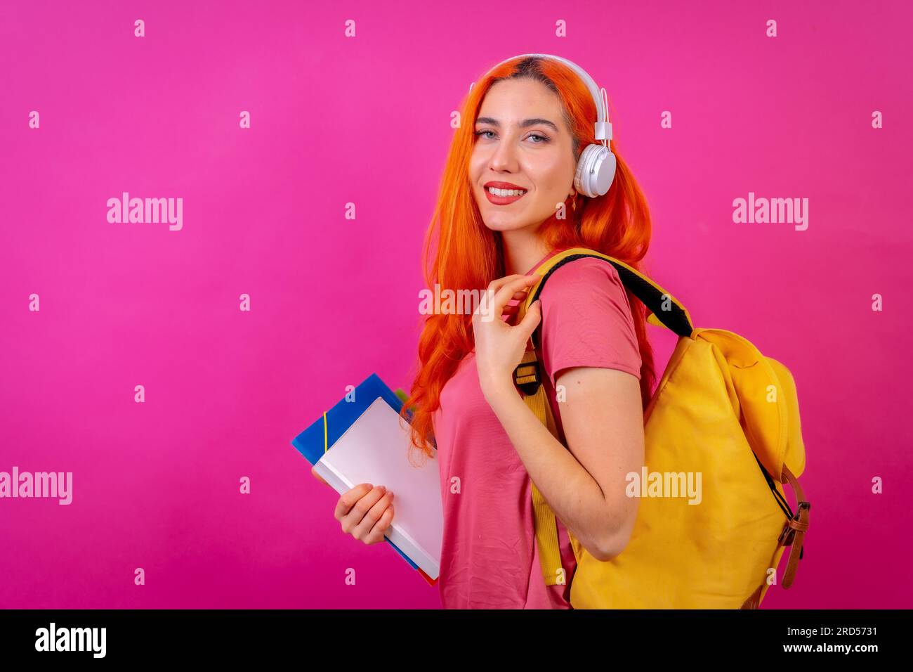 Redhead woman in studio photography dancing college student on a pink ...
