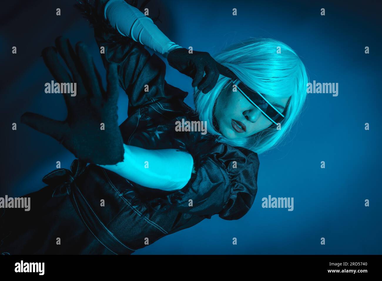 Portrait of cosplay woman in black costume and a white wig in studio ...