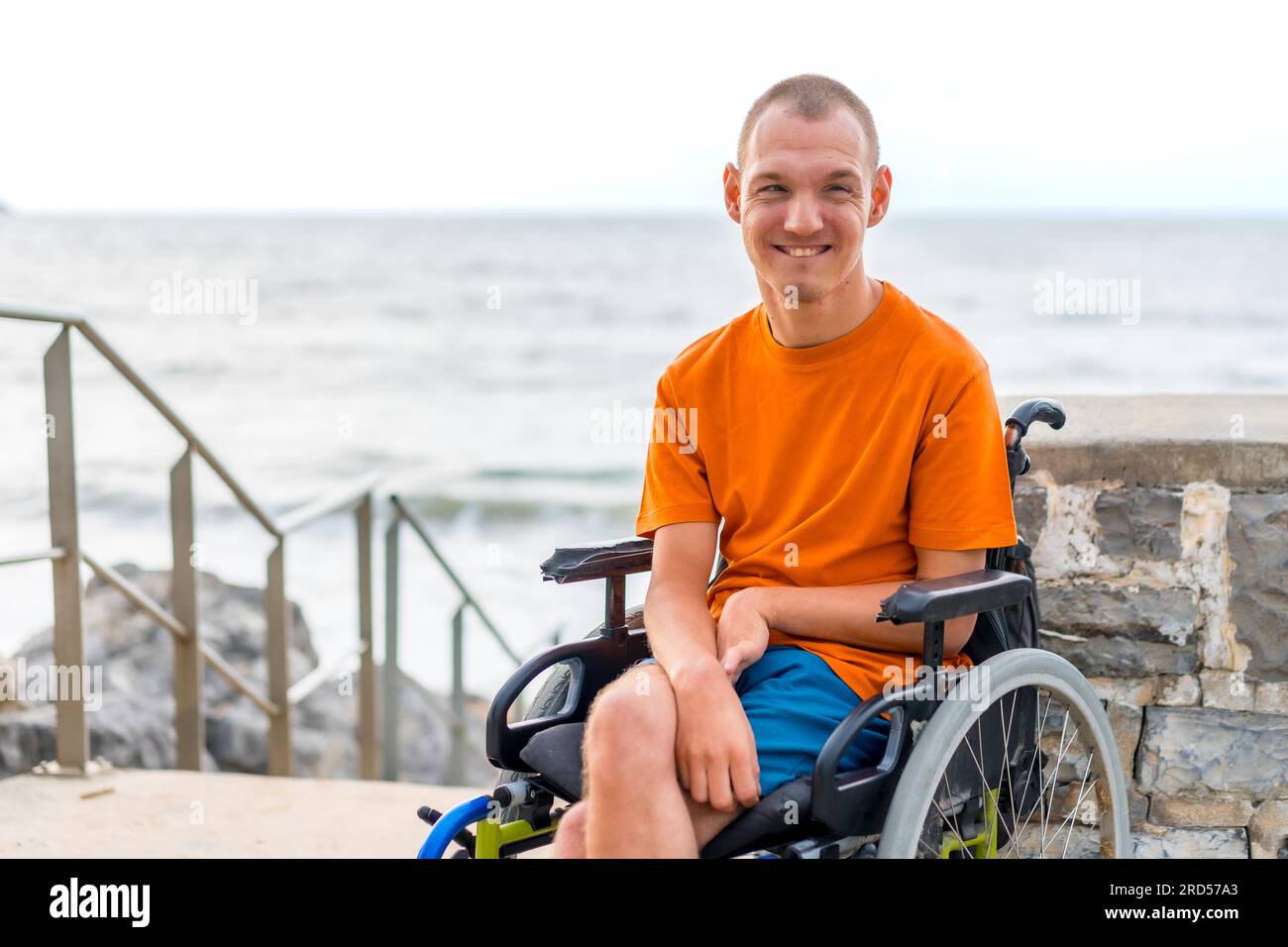 Portrait of a disabled person in a wheelchair on the beach on summer ...