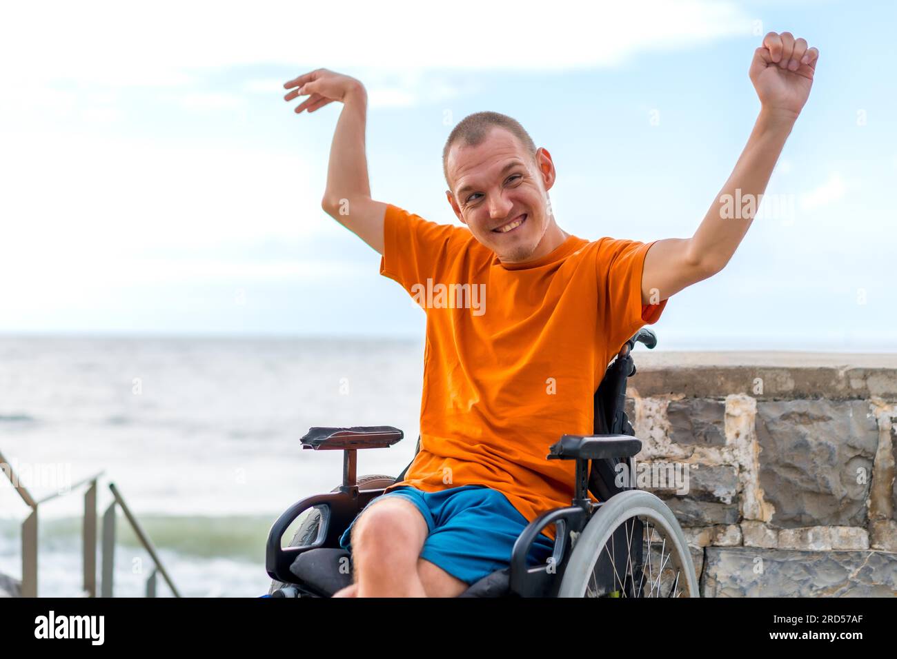 Portrait of pretty cheerful disabled person in wheelchair at the beach ...