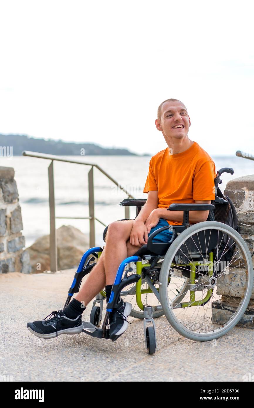 Portrait of pretty cheerful disabled person in wheelchair at the beach ...