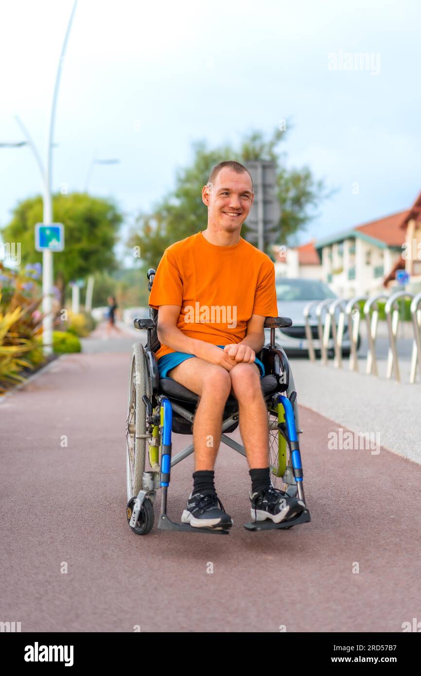 Portrait of a very cheerful disabled person in a wheelchair at the ...