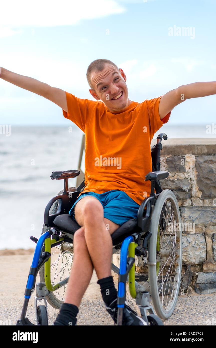 Portrait of pretty cheerful disabled person in wheelchair at the beach ...