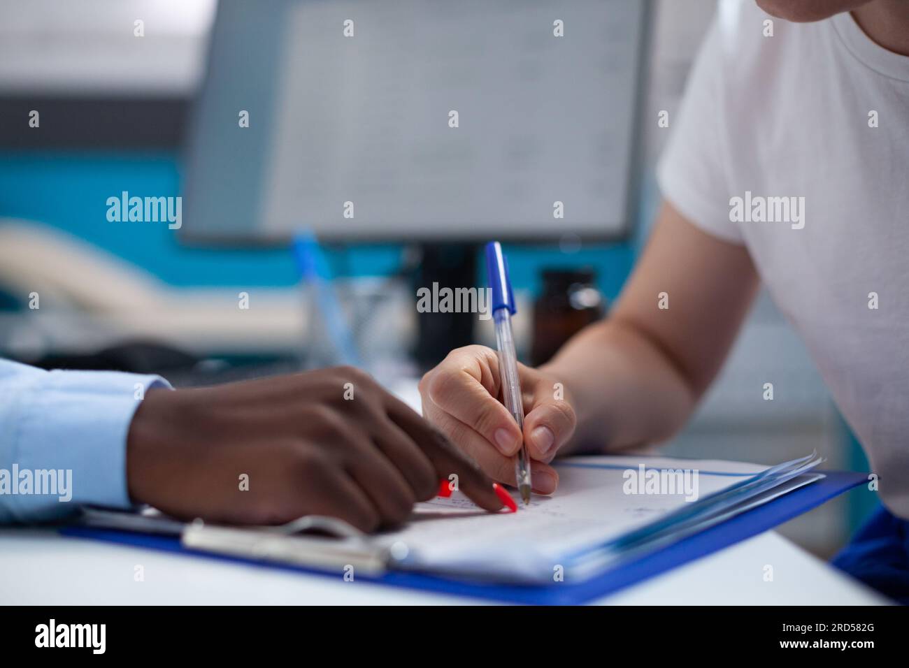 Patient writing signature on medical insurance report application form ...
