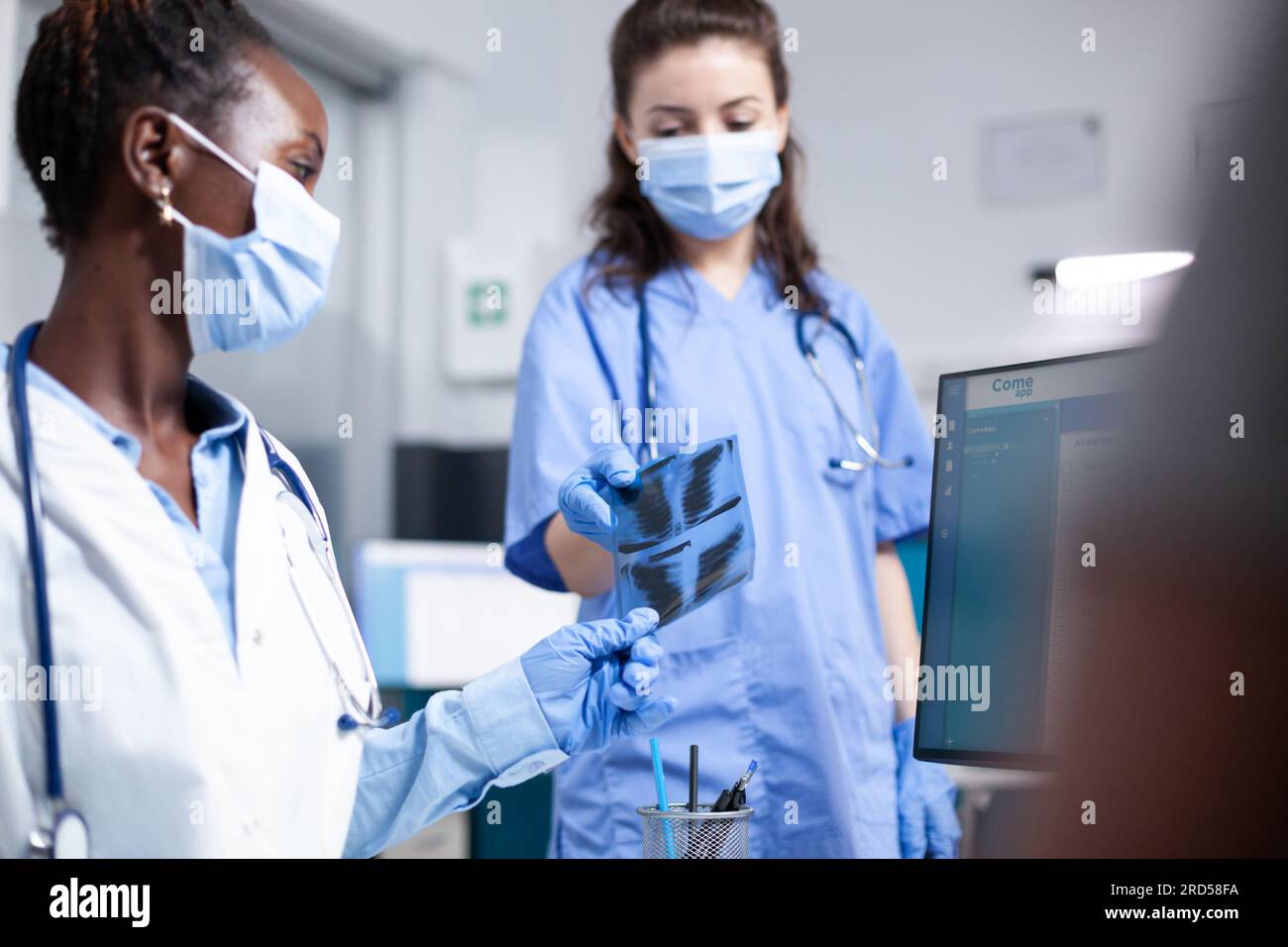 Nurse offering doctor x-ray tomography scan of patient ribcage ...