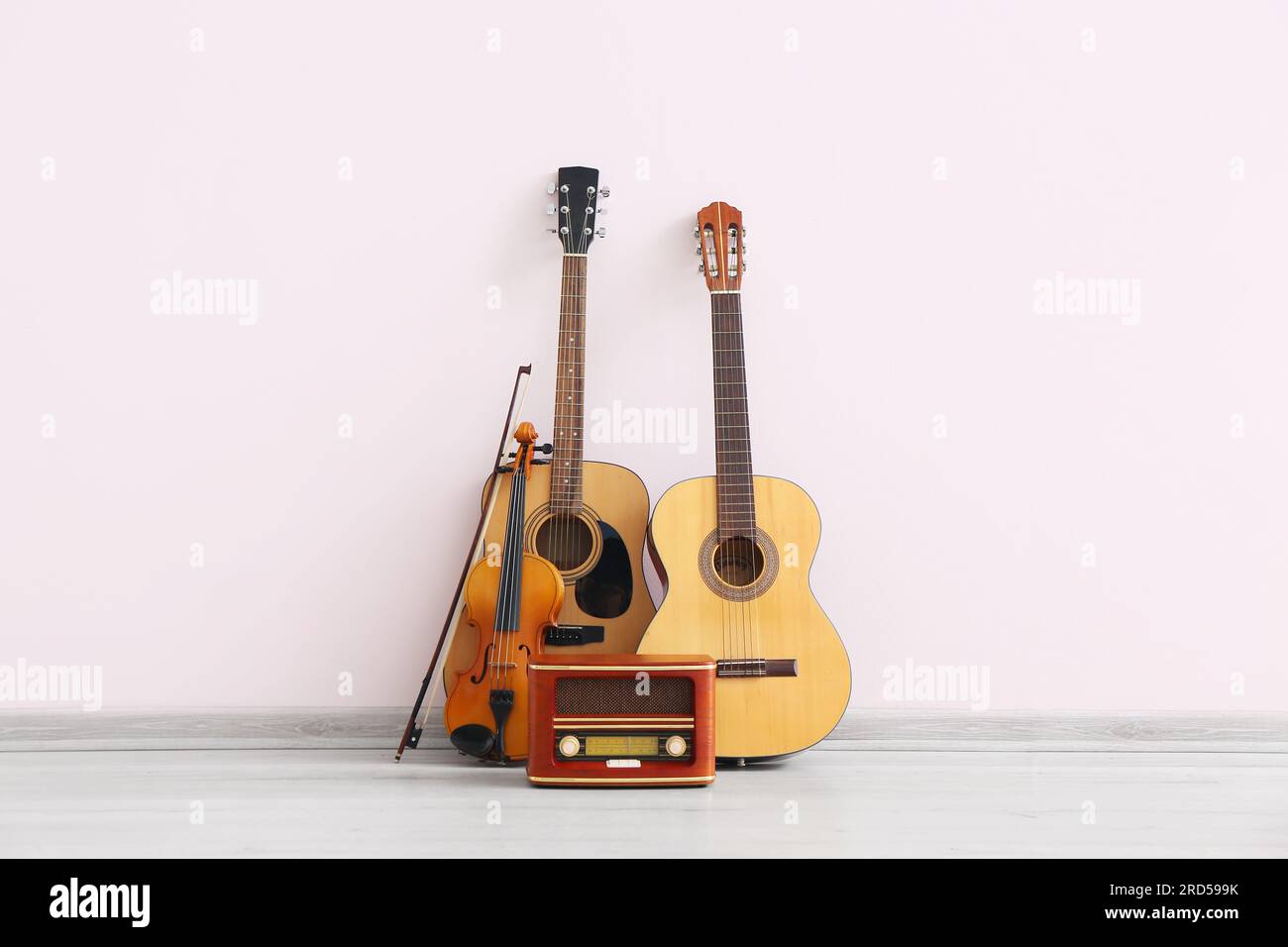 Different musical instruments and retro radio receiver near light wall ...