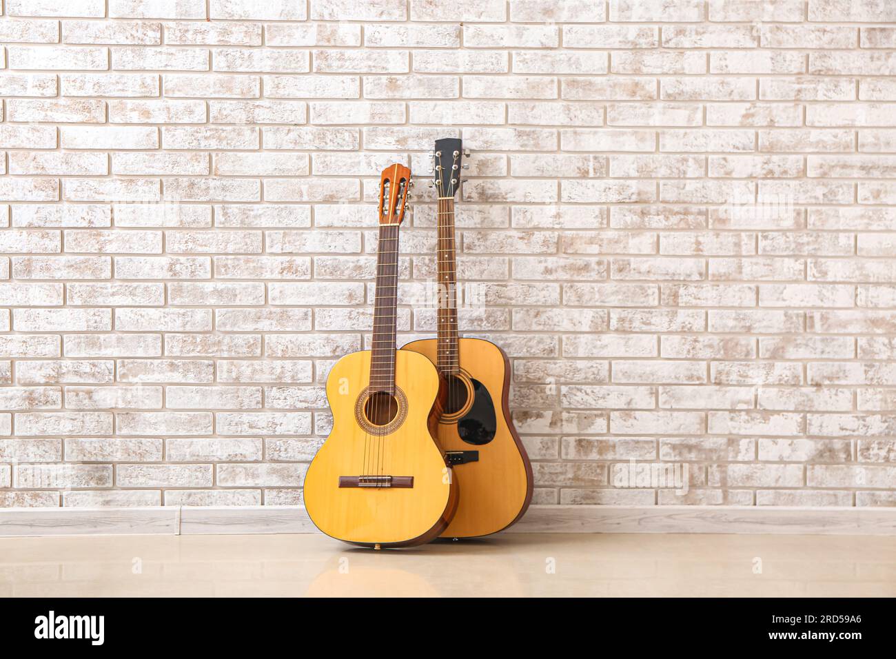 Two guitars near brick wall Stock Photo - Alamy