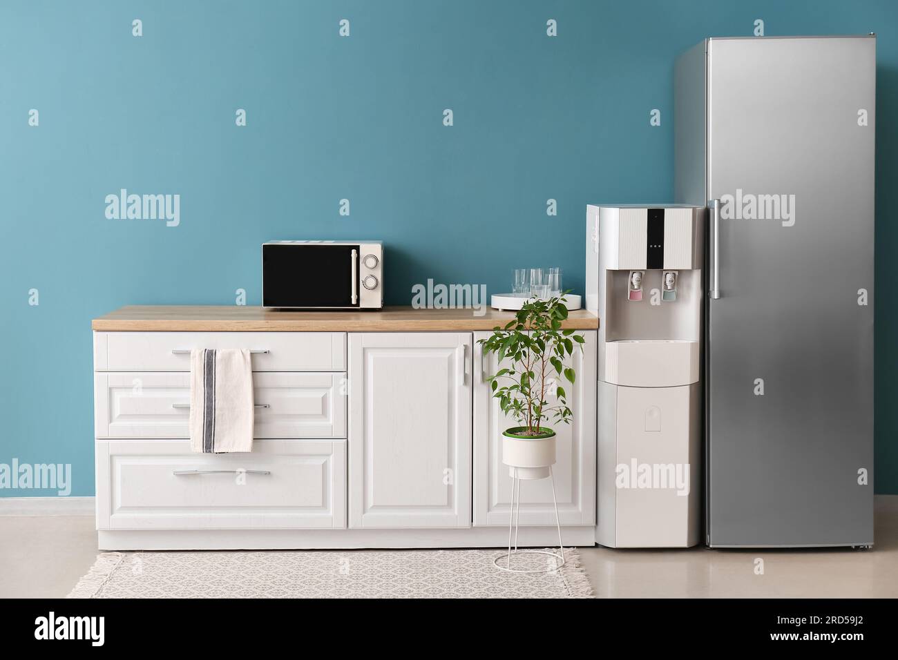 Interior of kitchen with modern water cooler near blue wall Stock Photo ...