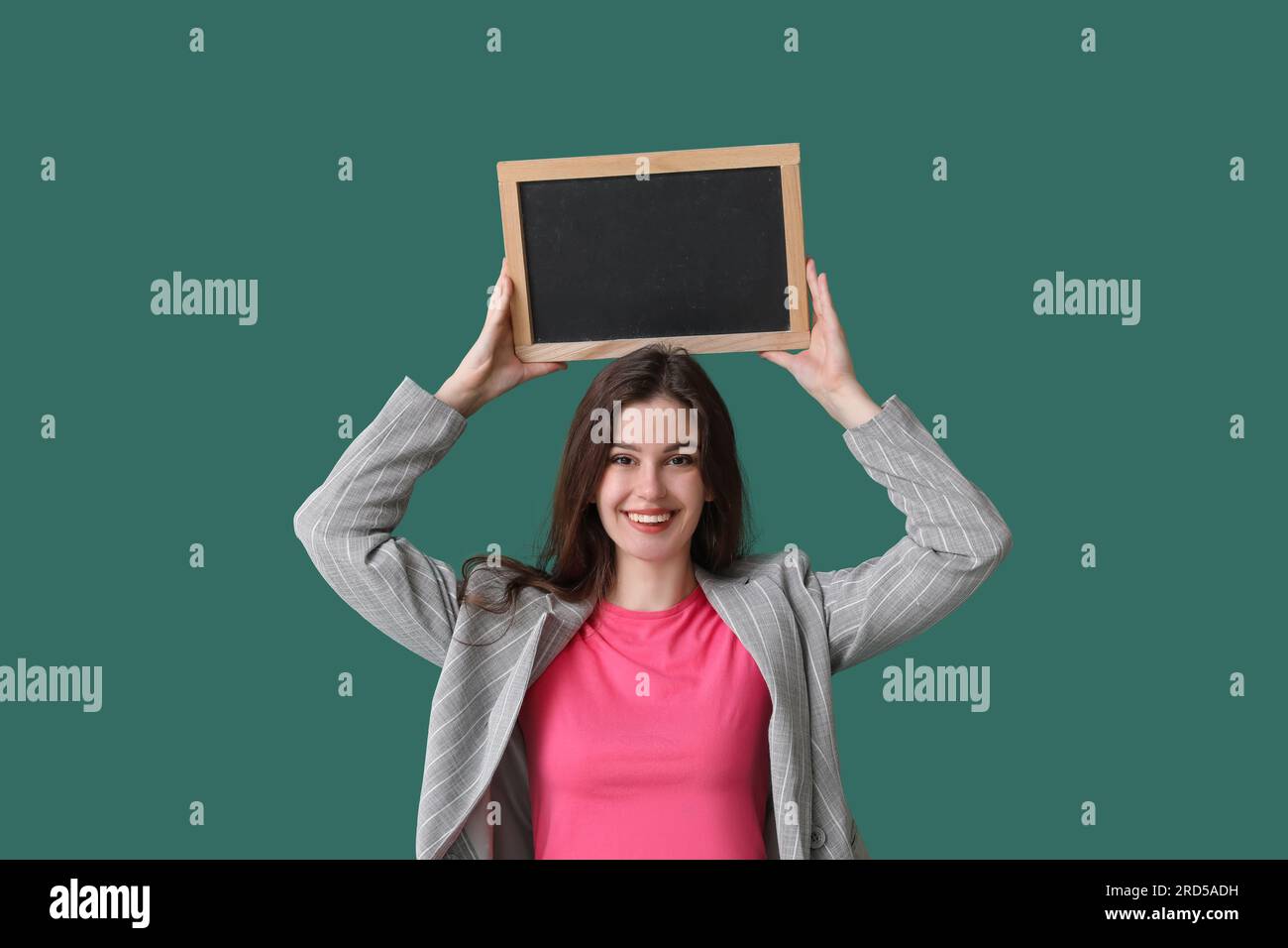 Female teacher with chalkboard on green background Stock Photo - Alamy
