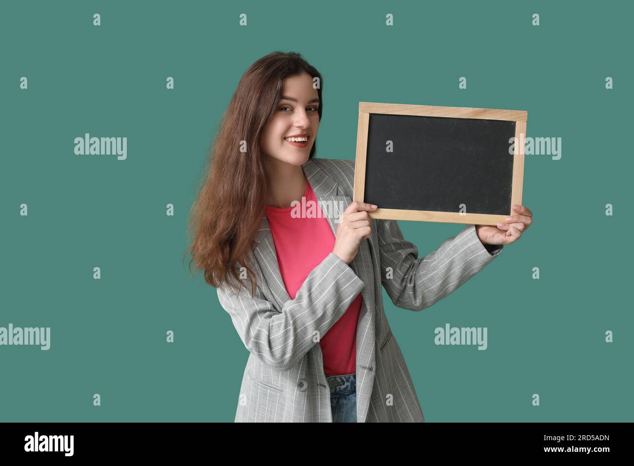 Female teacher with chalkboard on green background Stock Photo - Alamy