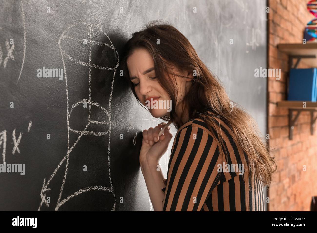 Stressed female Math teacher near blackboard in classroom Stock Photo ...