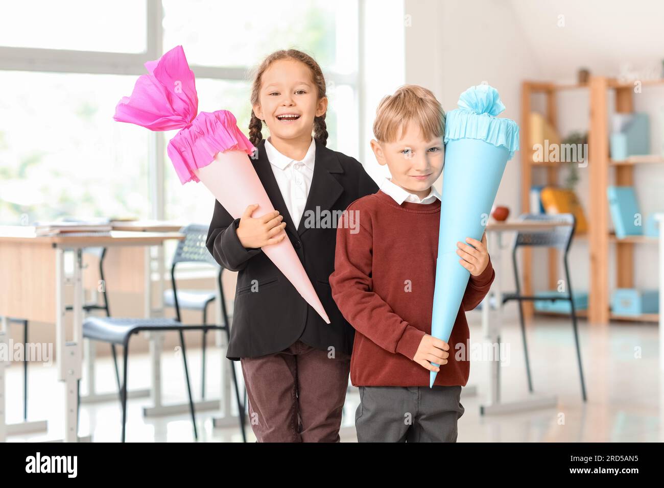 Happy classmates with colorful school cones in classroom Stock Photo ...