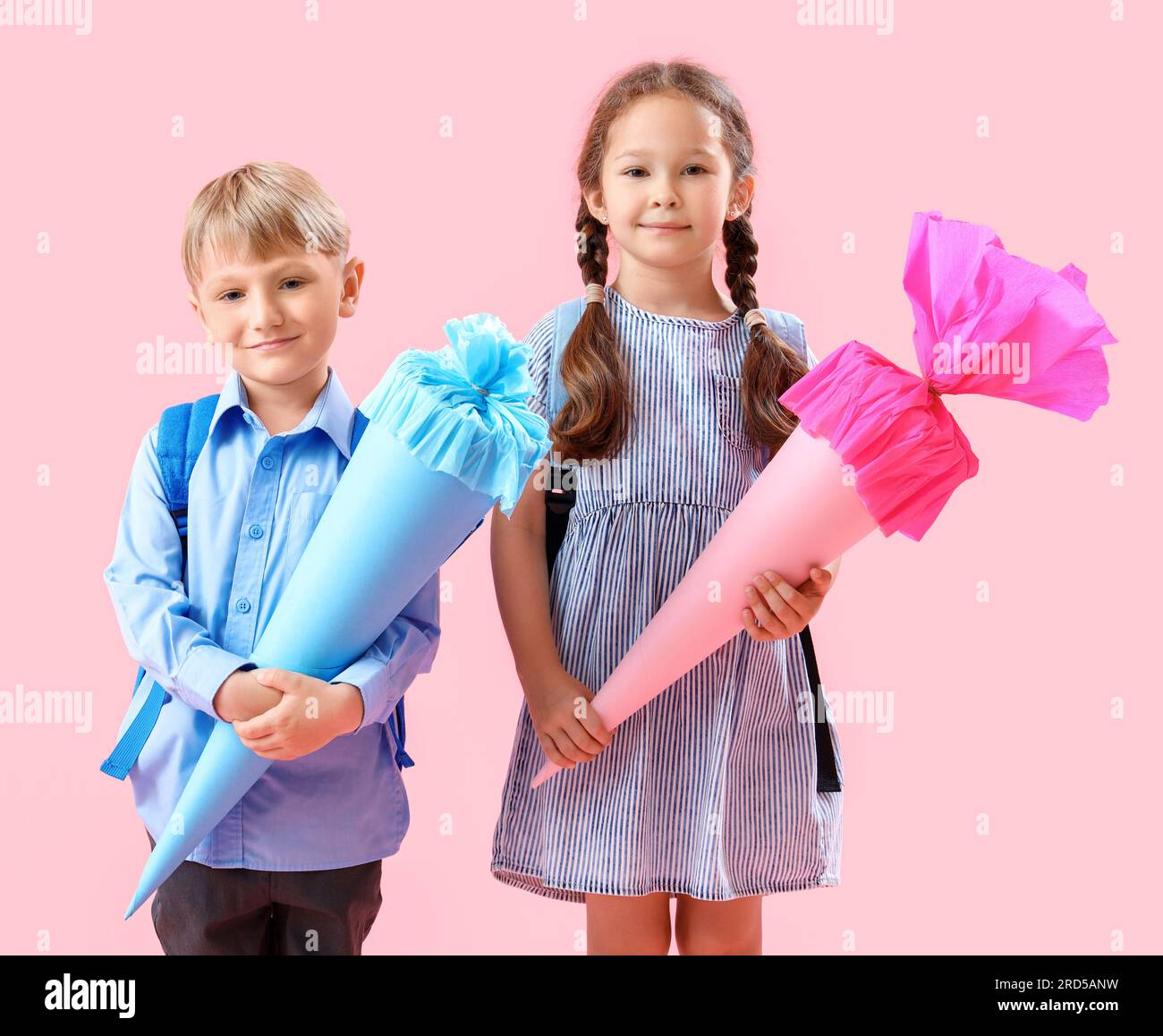 Happy little classmates with backpacks and colorful school cones on ...