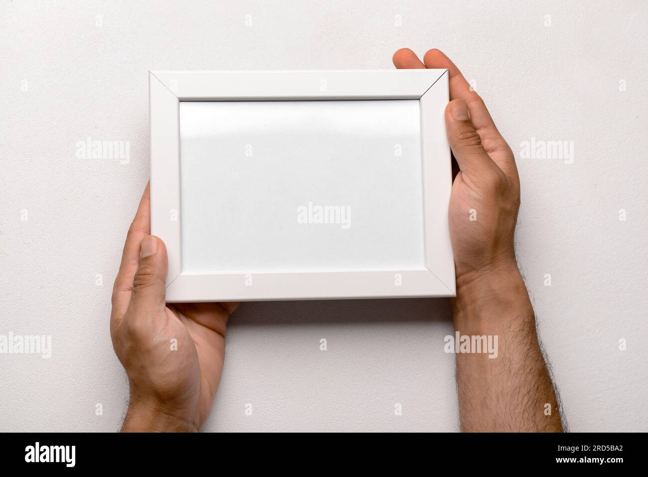 Man holding blank photo frame on white background Stock Photo - Alamy