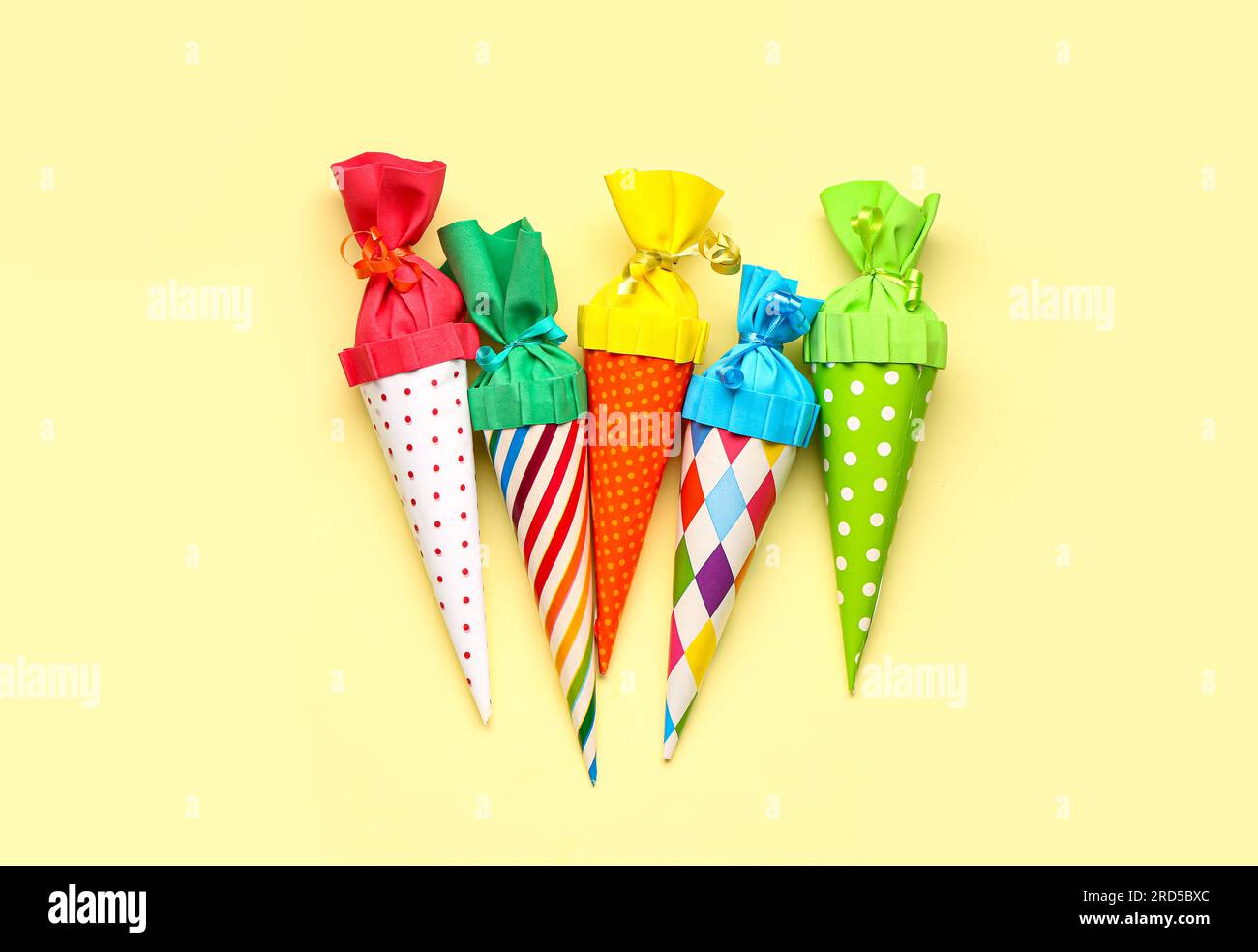 Colorful school cones on yellow background Stock Photo - Alamy