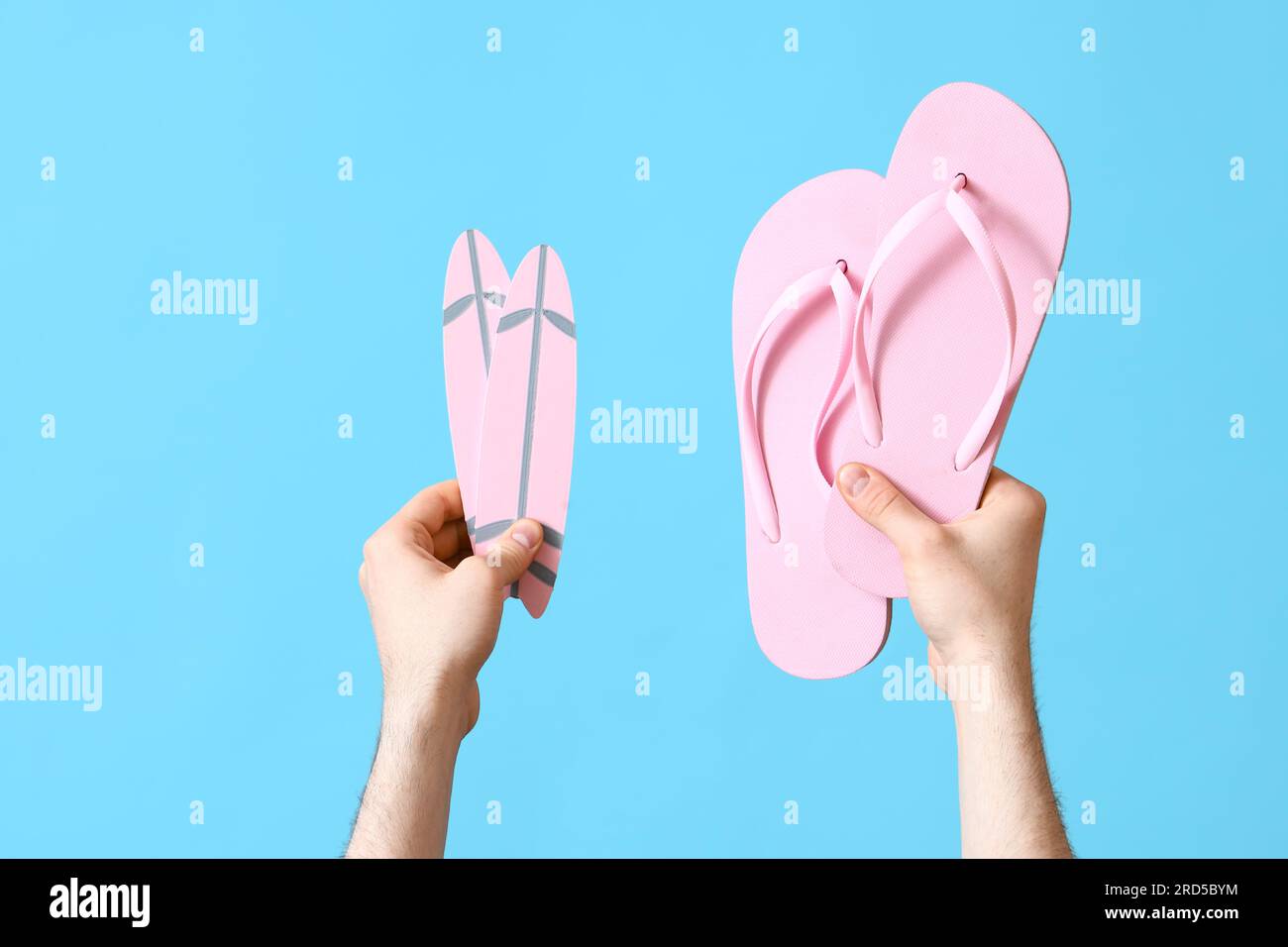 Male hands with flip flops and mini surfboards on blue background Stock ...