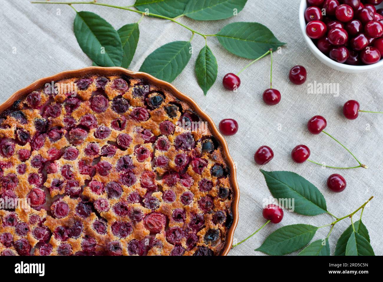 Delicious cherry clafoutis in round baking dish on light background ...