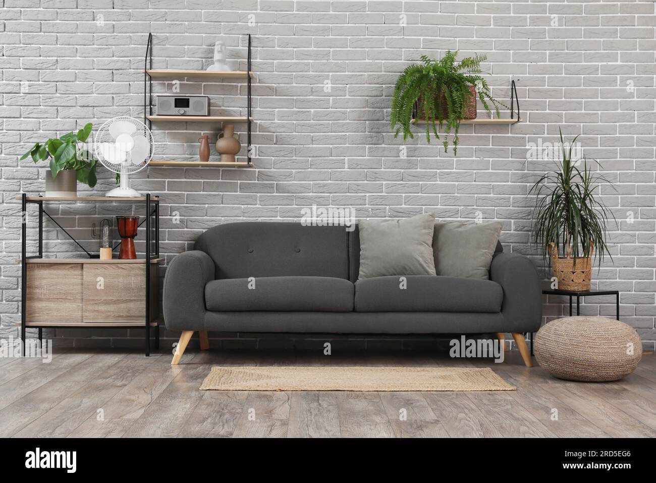 Interior of modern living room with sofa and electric fan on shelf ...