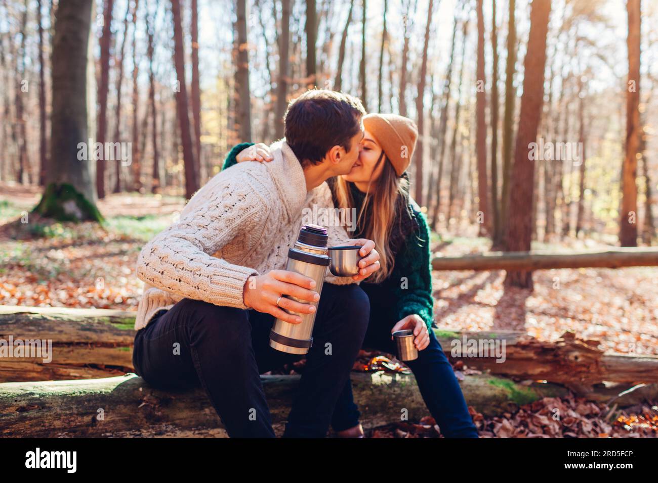 Happy loving couple kissing drinking tea from thermos relaxing in ...