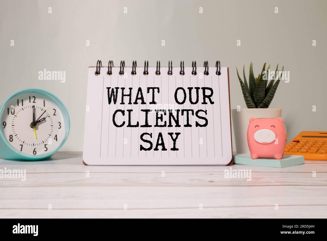 What Our Clients Say statement on paper note pad. Office desk with ...
