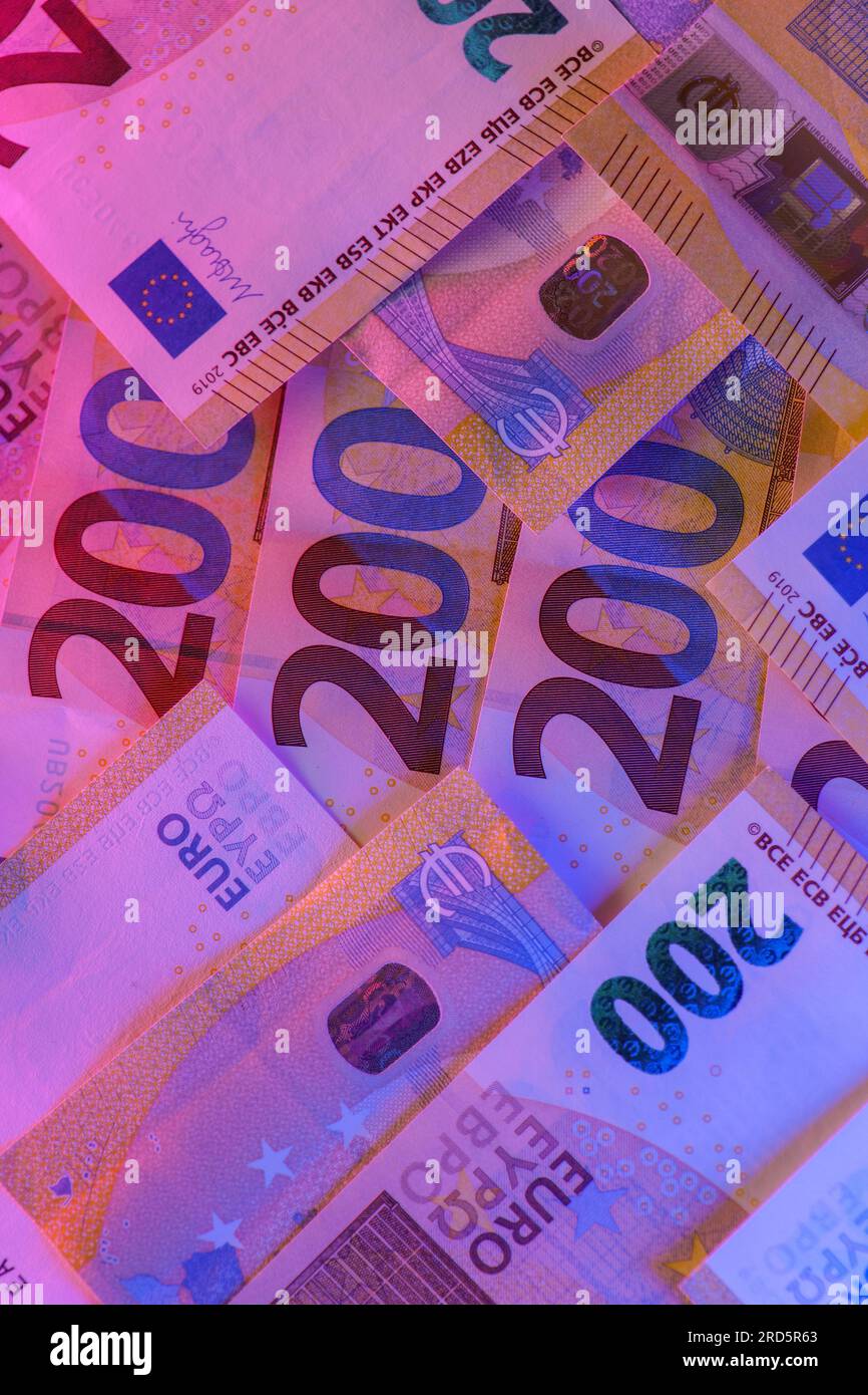 EU currency. Two hundred euro bills close-up in purple neon light ...