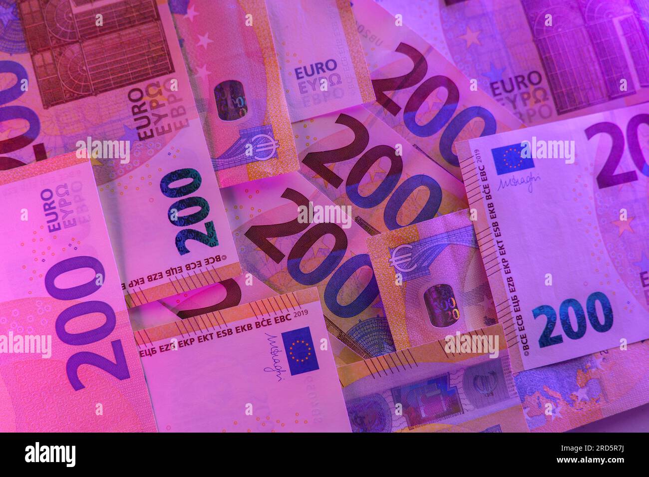 Money colored background. Two hundred euro bills close-up in purple ...