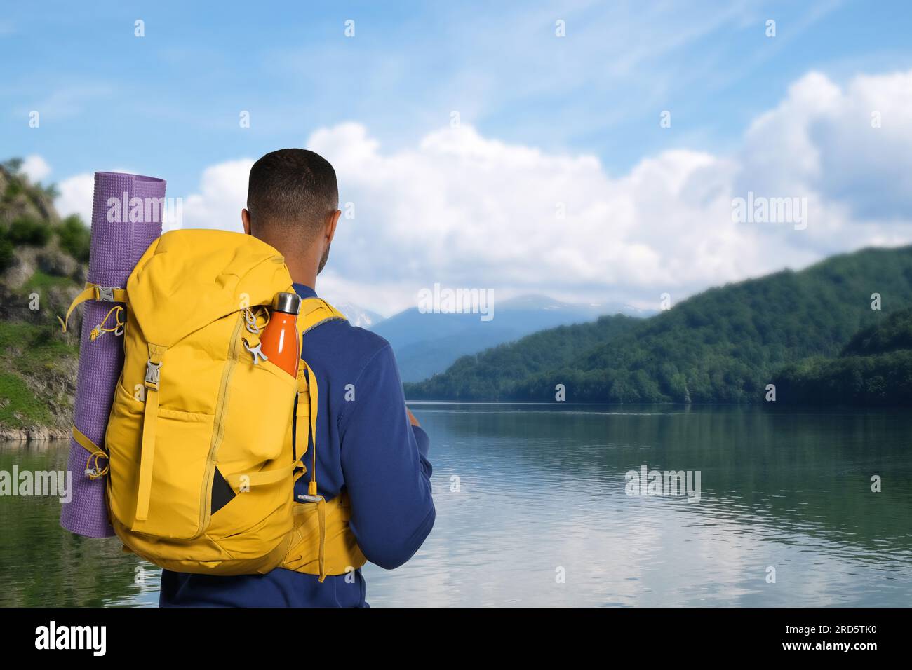 Tourist with backpack near lake, back view Stock Photo - Alamy