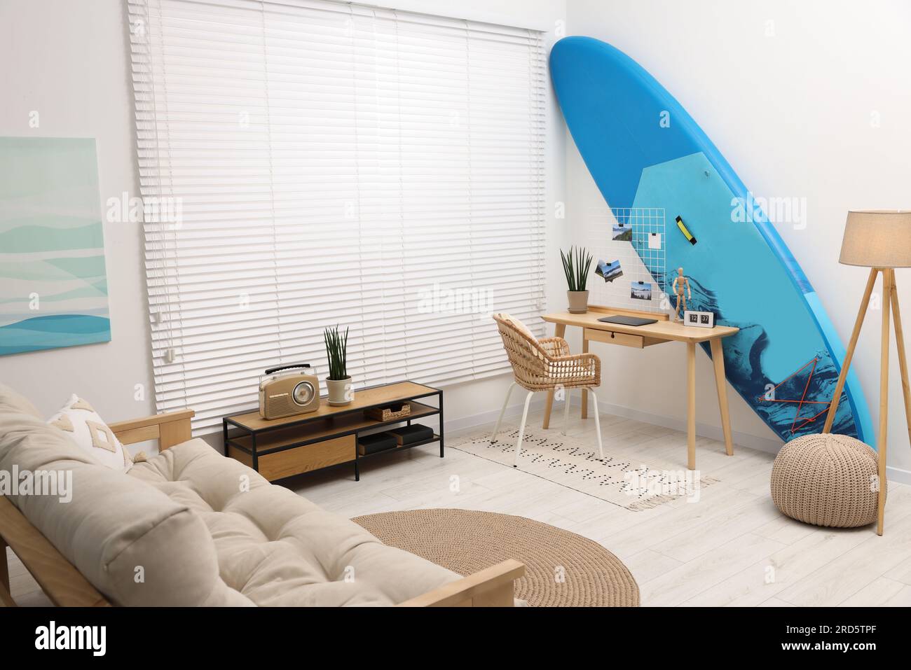 SUP board, workplace and sofa in room. Interior design Stock Photo - Alamy