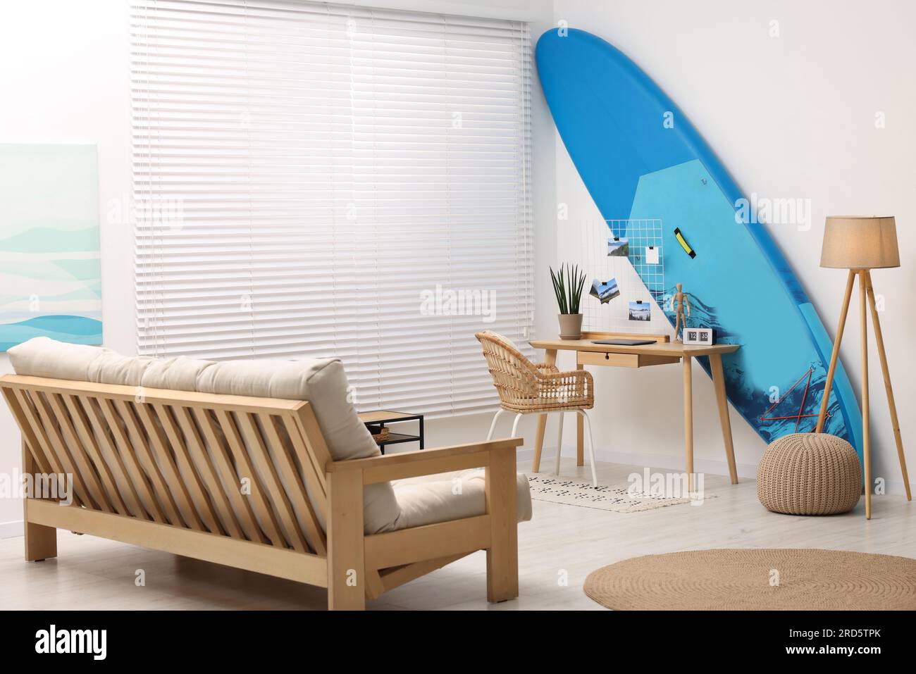 SUP board, workplace and sofa in room. Interior design Stock Photo - Alamy