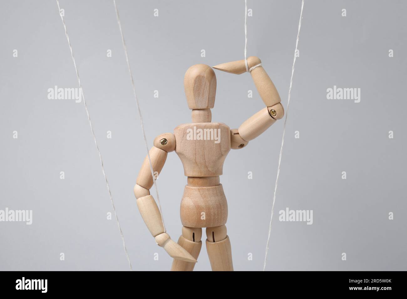 One wooden puppet with strings on light grey background Stock Photo - Alamy