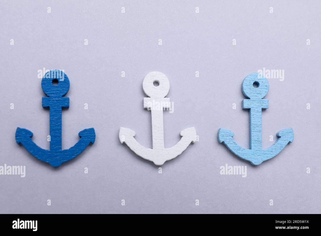 Anchor figures on light grey background, flat lay Stock Photo - Alamy