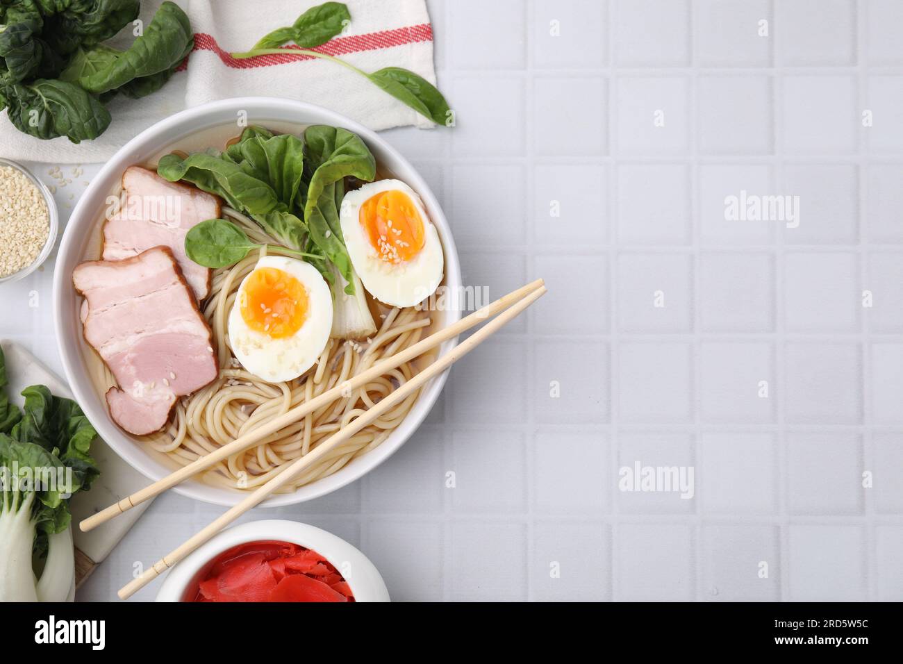 Delicious ramen with meat served on white tiled table, flat lay and ...