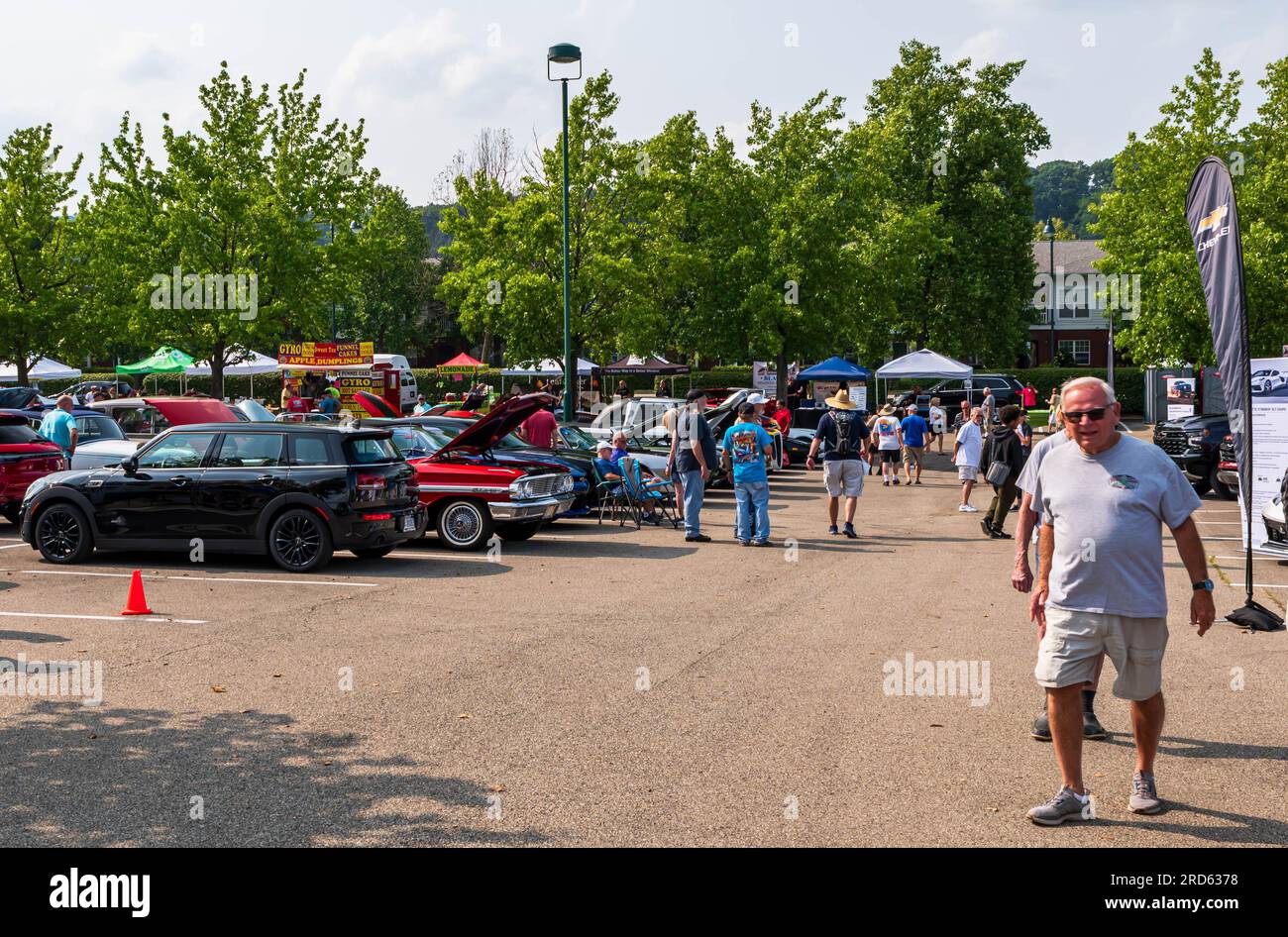 People walking around the cars at a car show in Homestead, Pennsylvania ...