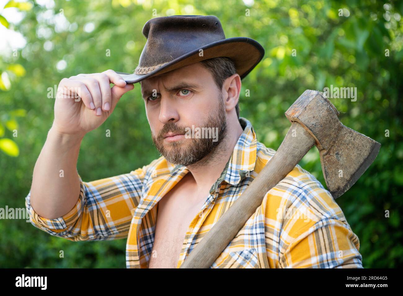 face of cowboy with axe. cowboy with axe wearing checkered shirt ...