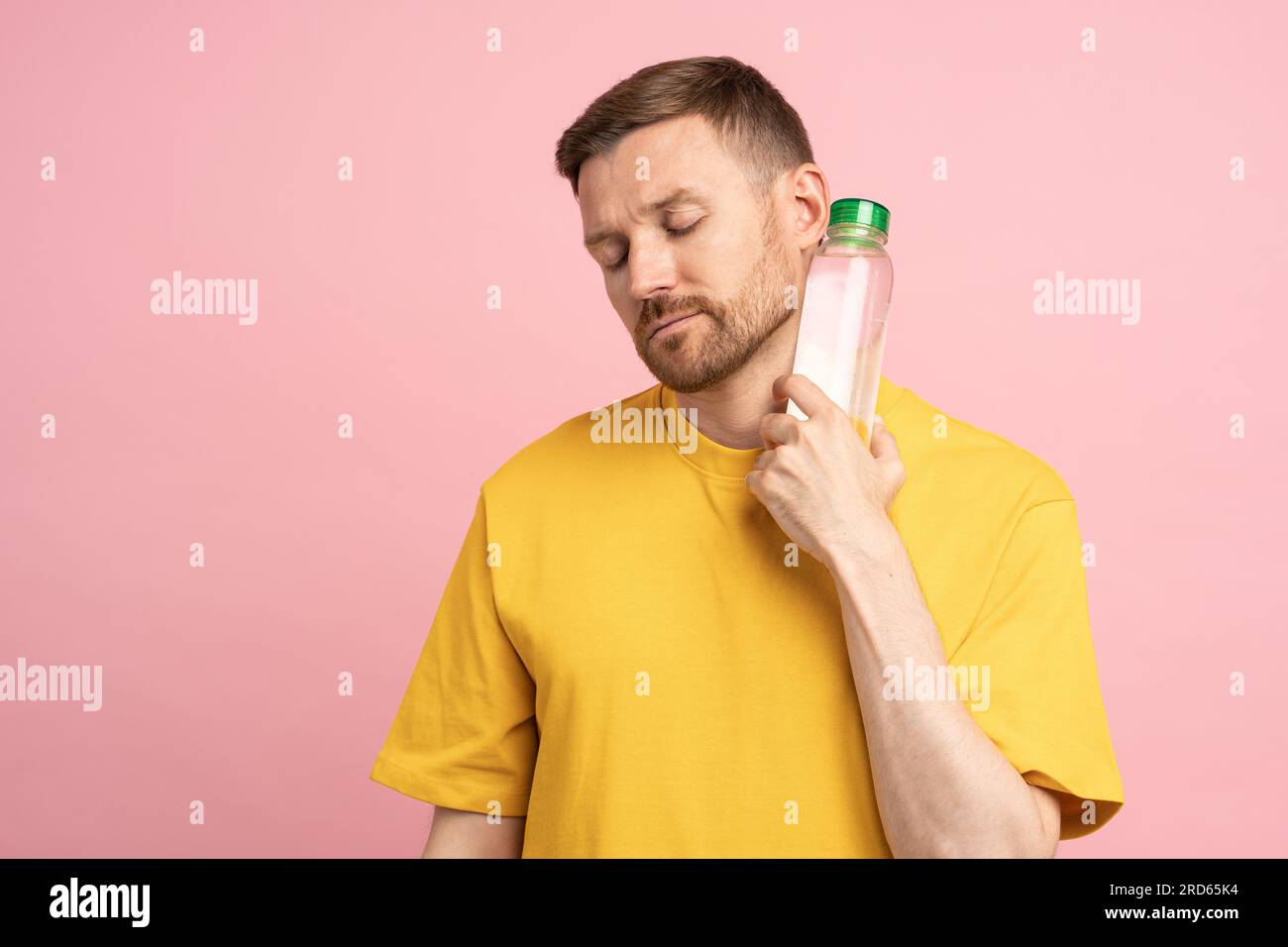 Tired man suffers from heat and blood pressure, puts bottle of cold ...