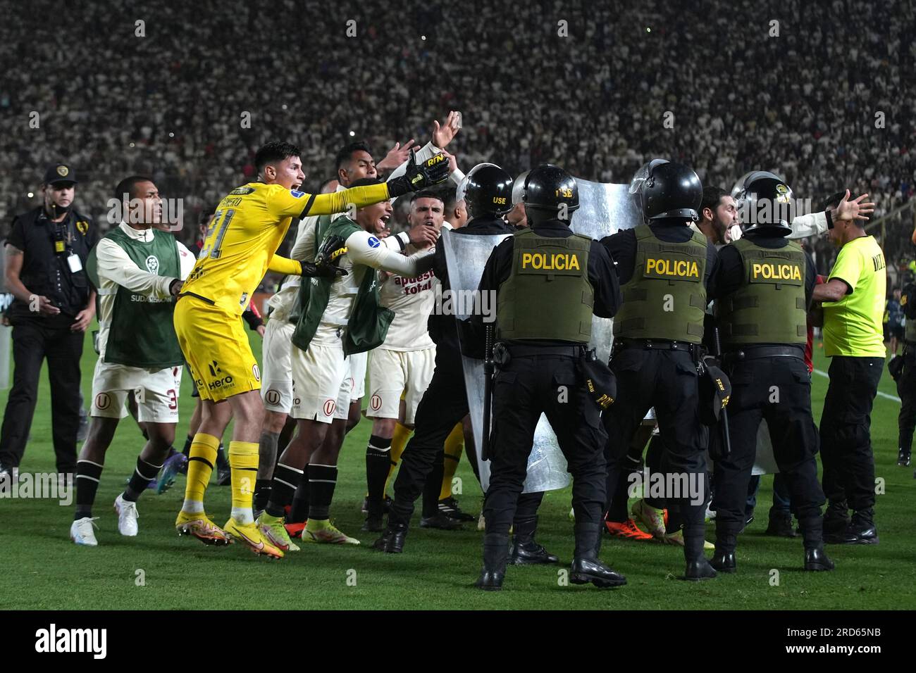 Peru's Universitario players are pushed by riot police during a scuffle ...