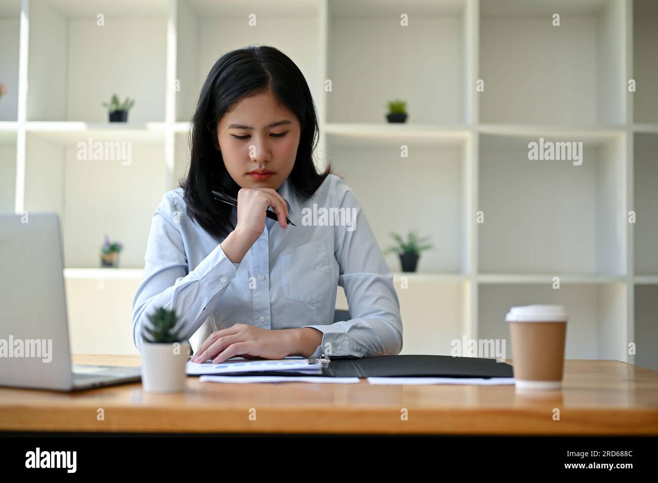 A serious and thoughtful Asian businesswoman planning her project and ...