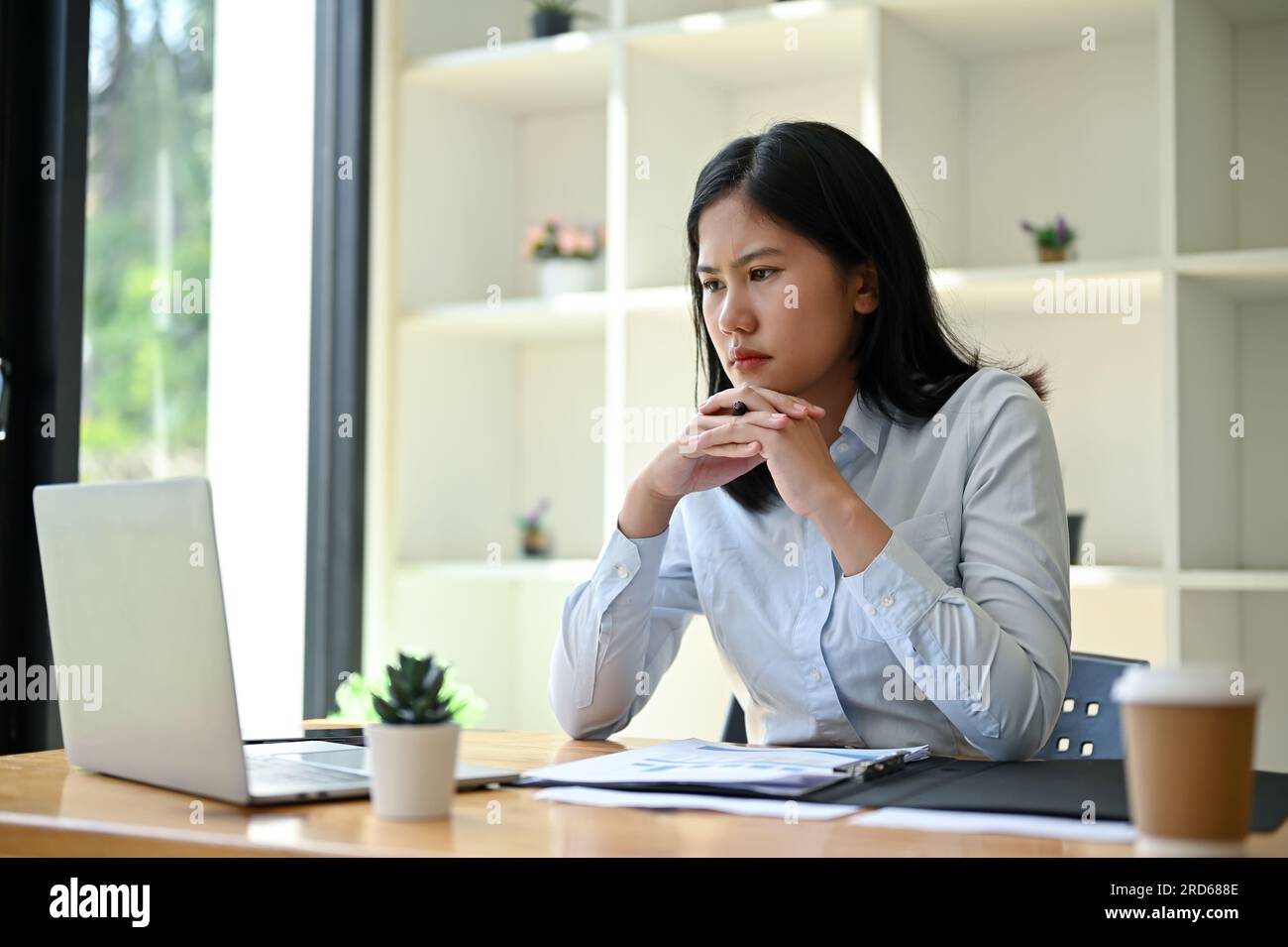 A stressed and professional millennial Asian businesswoman is looking ...
