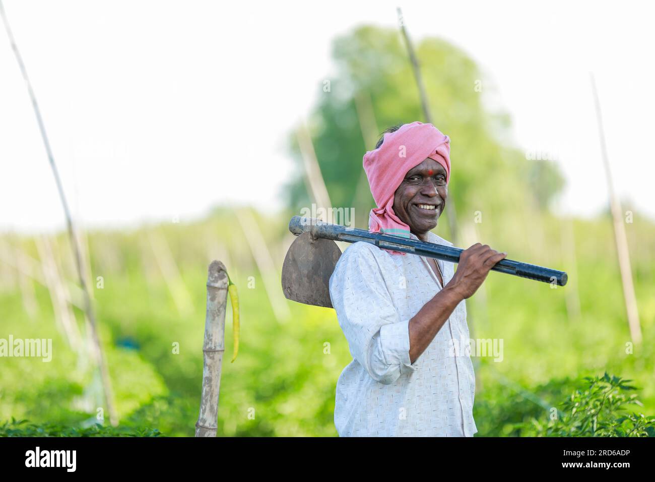 Happy Indian farmer, holding farming tools in hand Stock Photo - Alamy